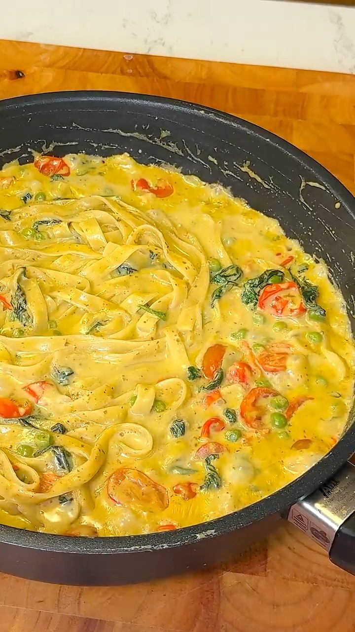 Pesto-Pasta aus einem Topf mit Kirschtomaten und Spinat