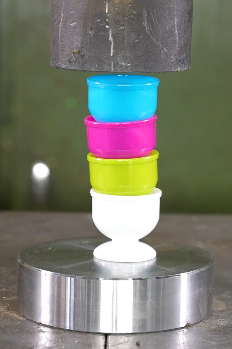 Hydraulic press crushing stacked plastic cups