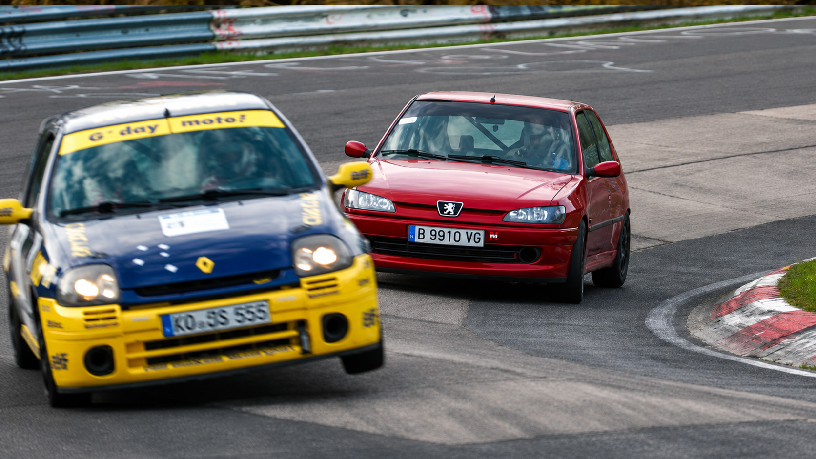 Tight battle between two small hatchbacks mid-corner at the Nürburgring ...