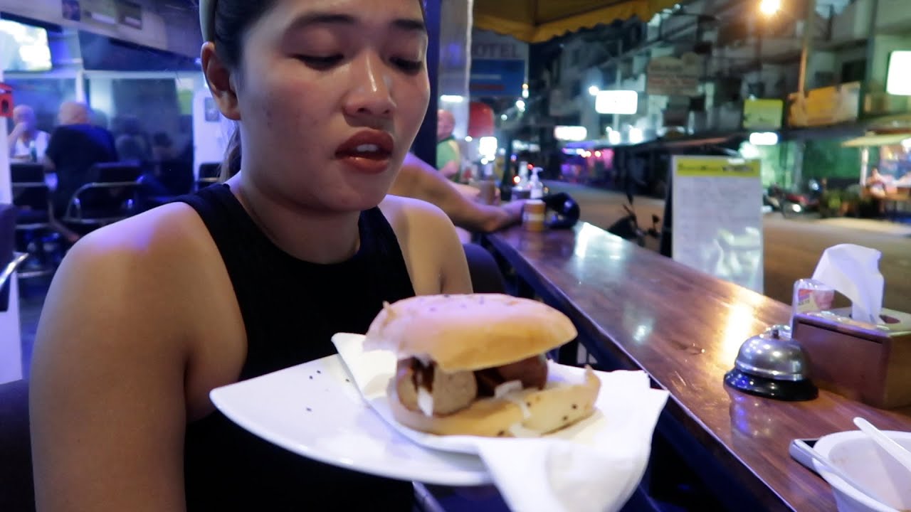 Thaise dame eet een frikandel in Pattaya