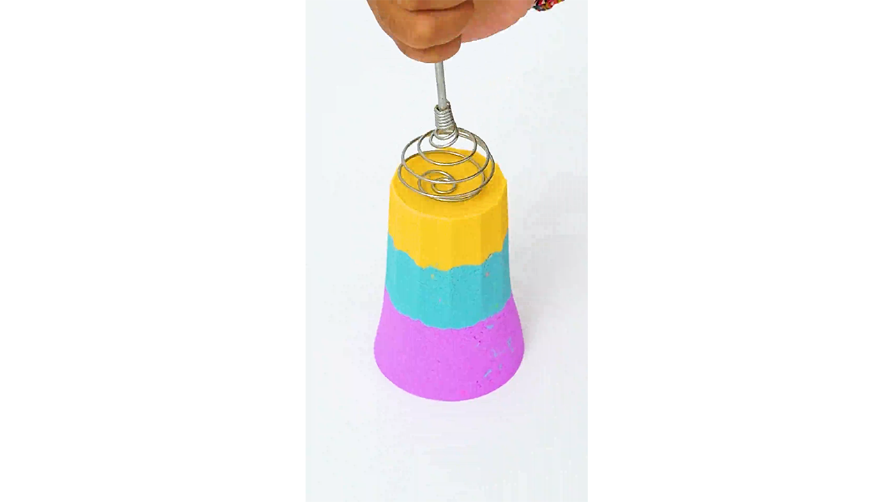 Satisfying twisting layered purple blue and yellow sand tower with ...