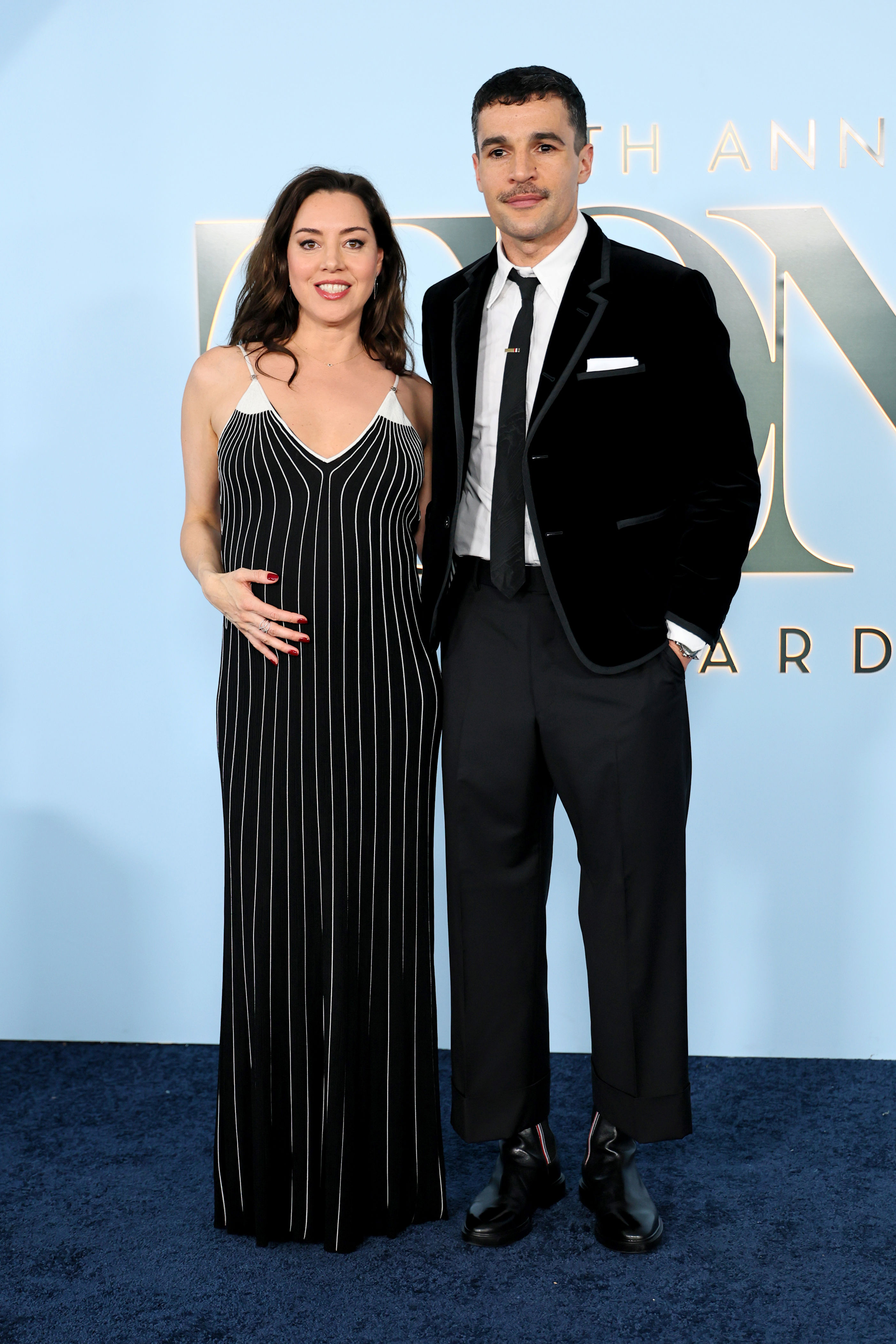 Aubrey Plaza cradles her baby bump while supporting partner Chris ...