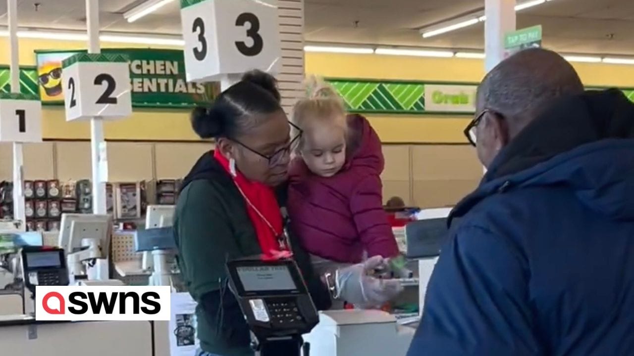Supermarket worker helps mum by picking up crying toddler