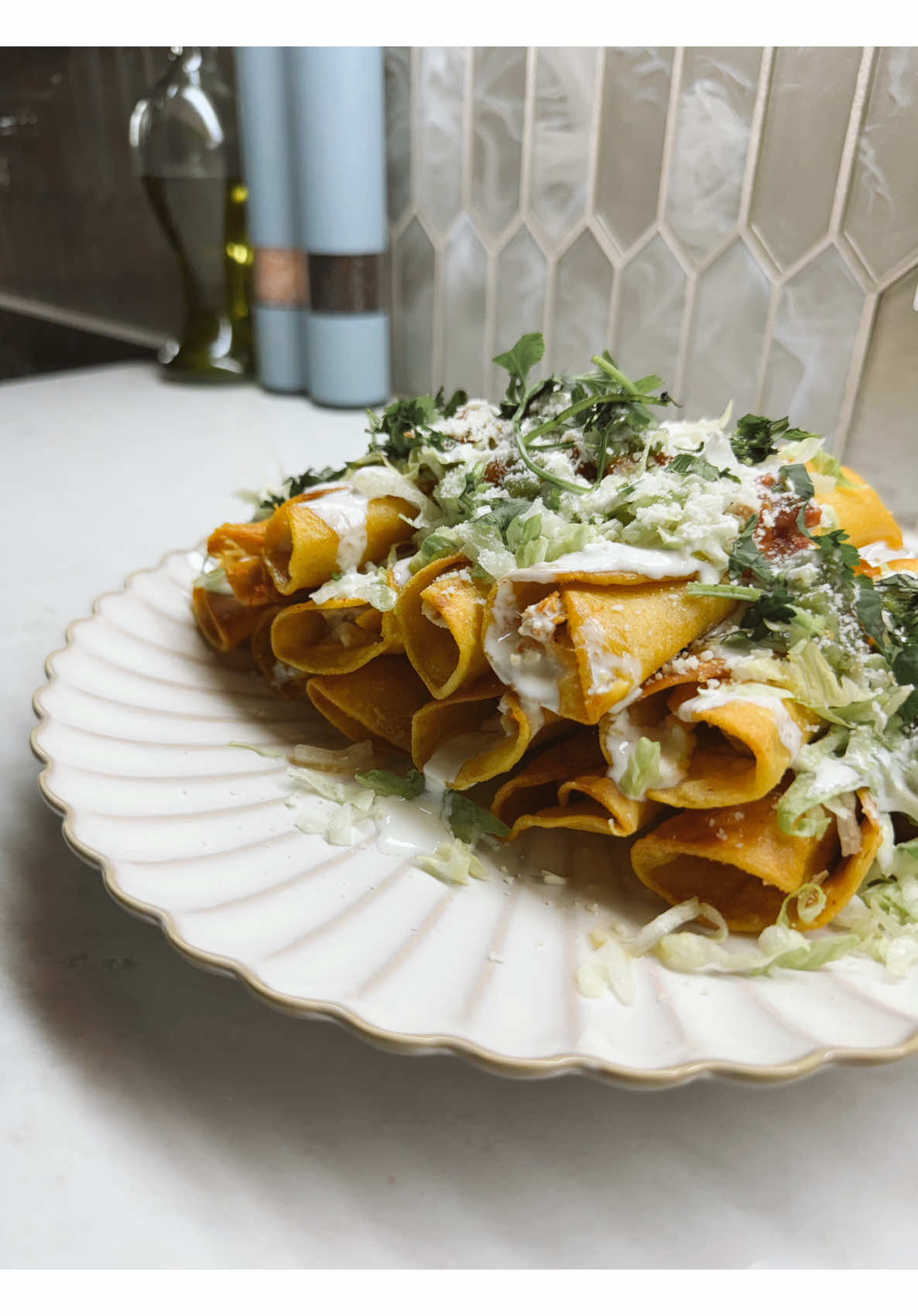 I made homemade crispy taquitos topped with sour cream, lettuce, and ...