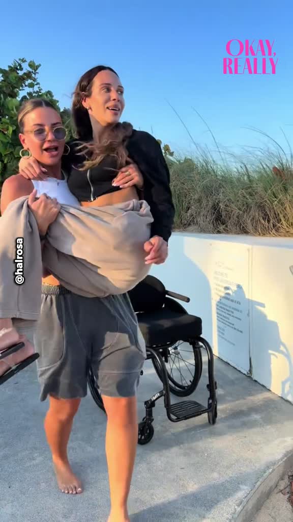 Friend carries woman in wheelchair onto beach for heartwarming picnic