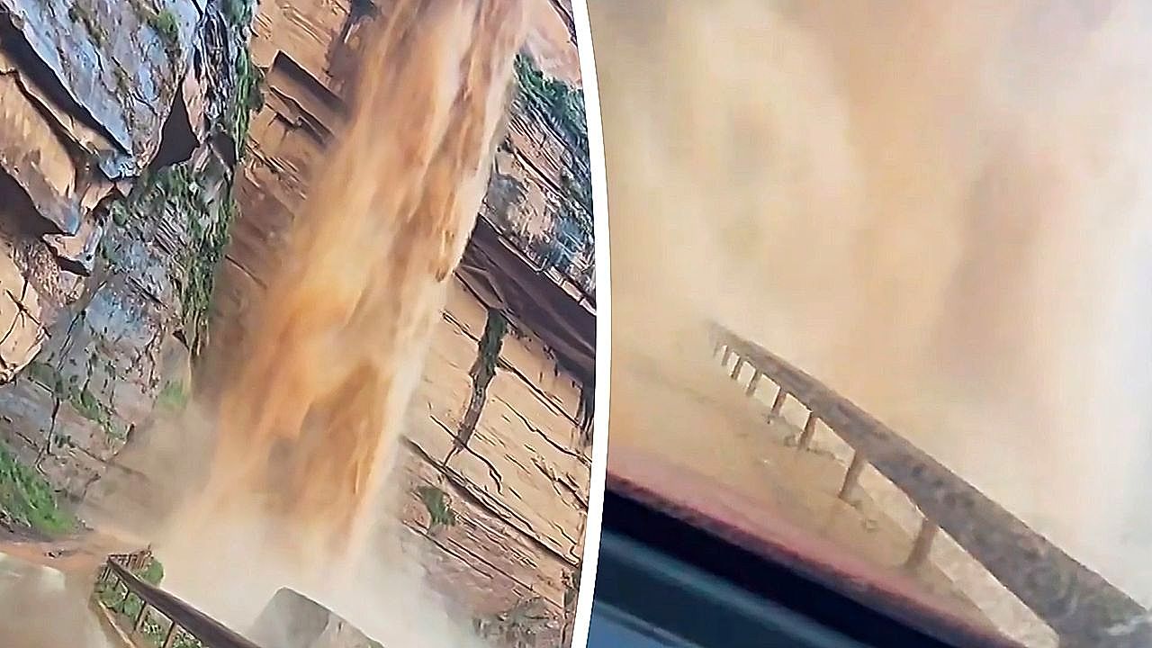 Un conducteur traverse une cascade d'eau boueuse sur une route de montagne