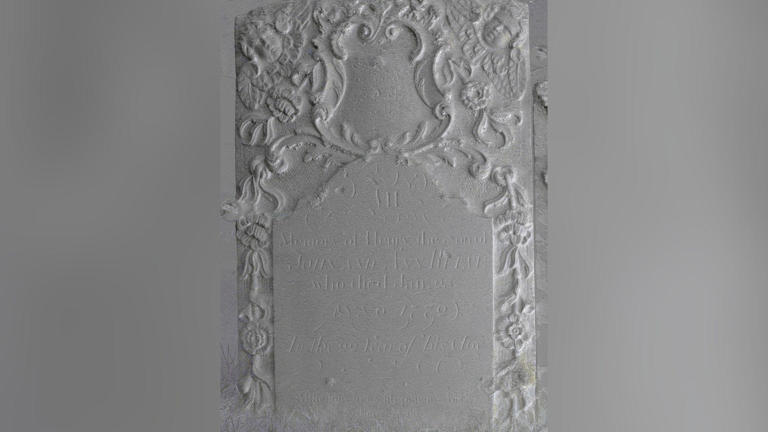Students identify heavily eroded gravestone