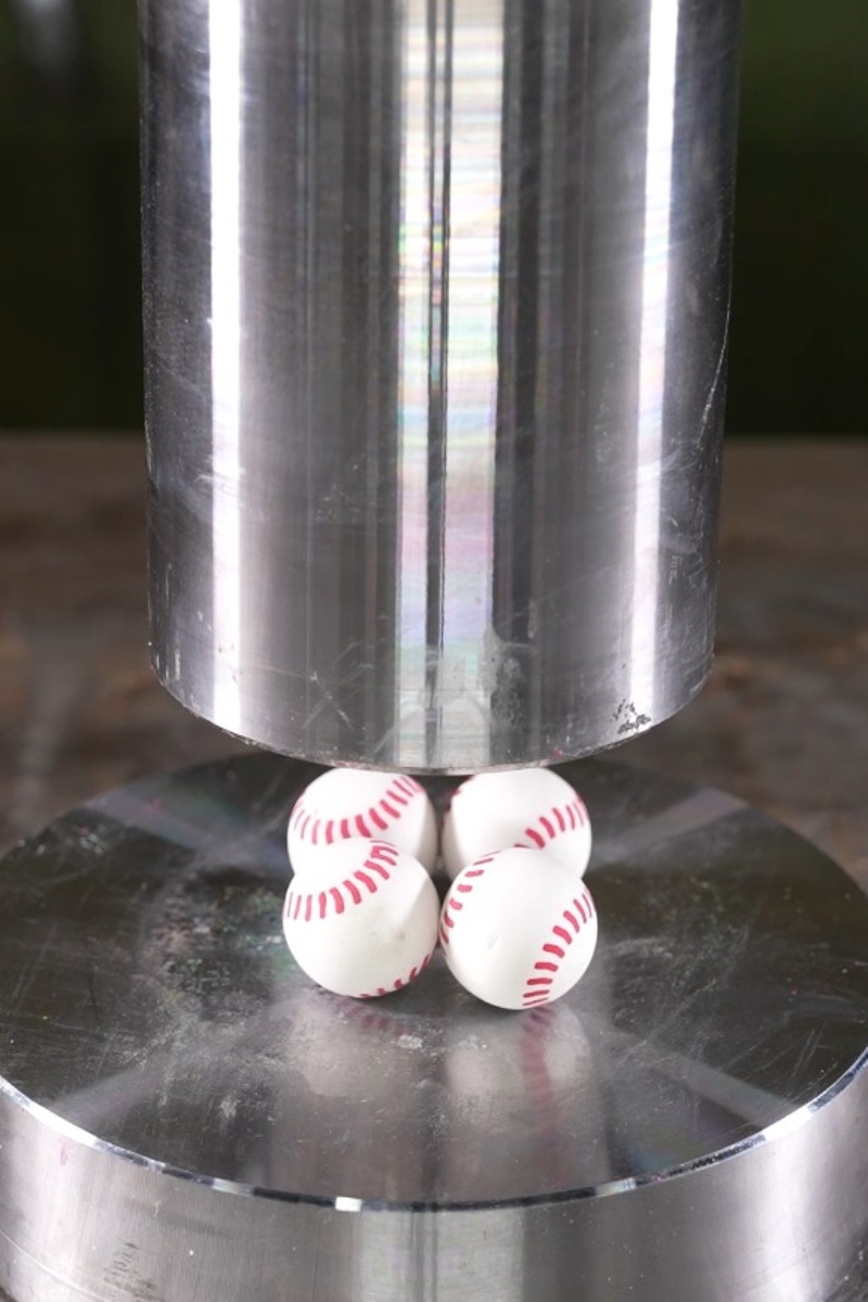 Baseballs unter hydraulischer Presse