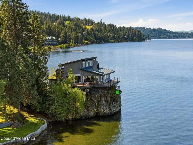 Glass-walled house perched on a giant lakeside rock makes it feel like ...