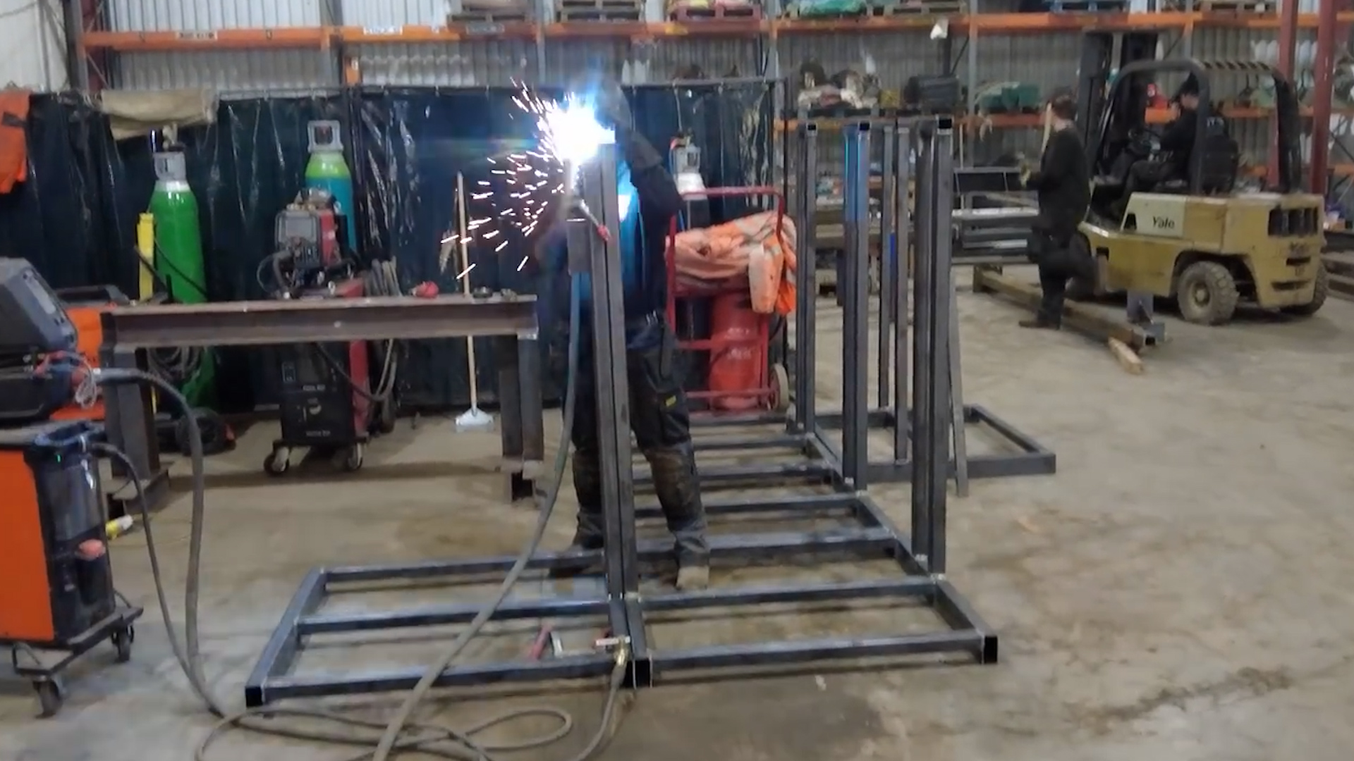Industrial welder assembling steel framework in fabrication workshop