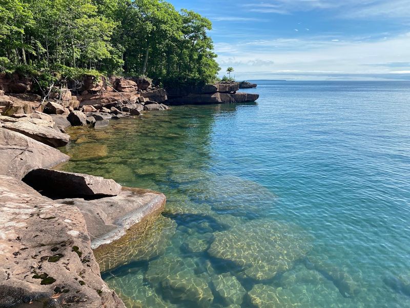 Ride a ferry to a Wisconsin beach where red cliffs drop into blue water