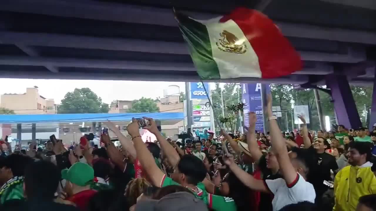 Mexico fans chant as they shelter under bridge during storm