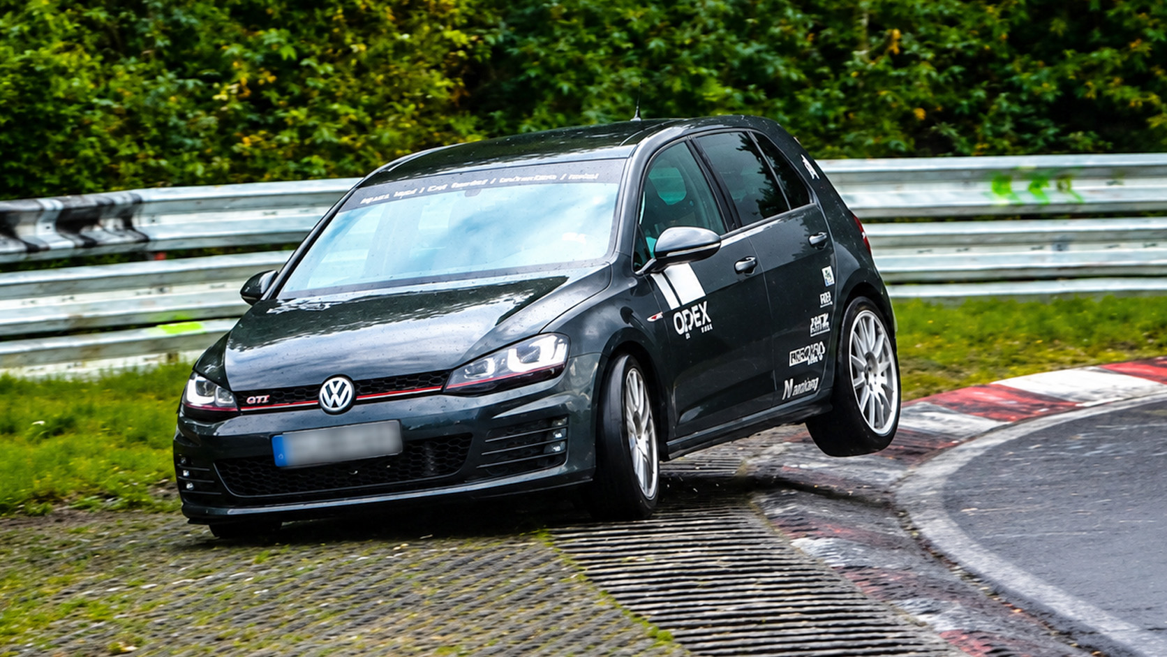 Volkswagen Golf misses the corner and lifts one wheel into the air