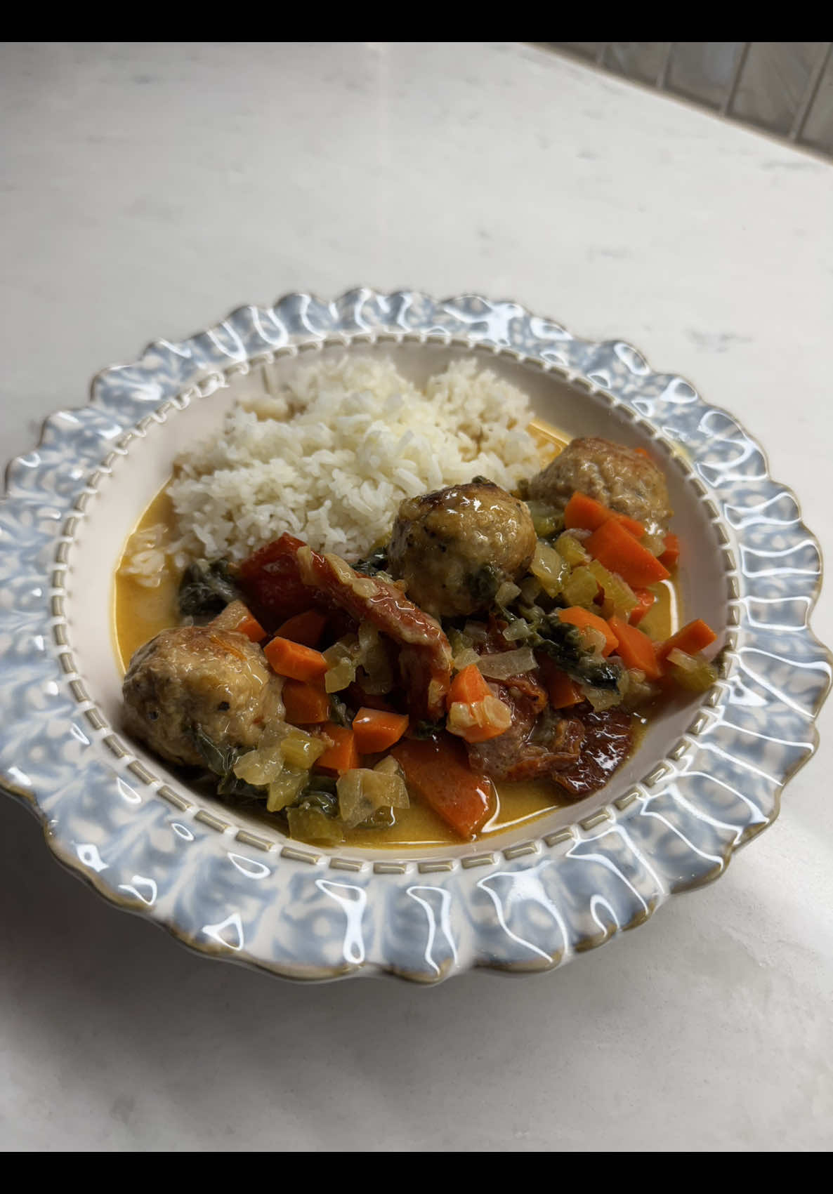 A hearty meatball and mixed vegetable stew served over warm and fluffy ...