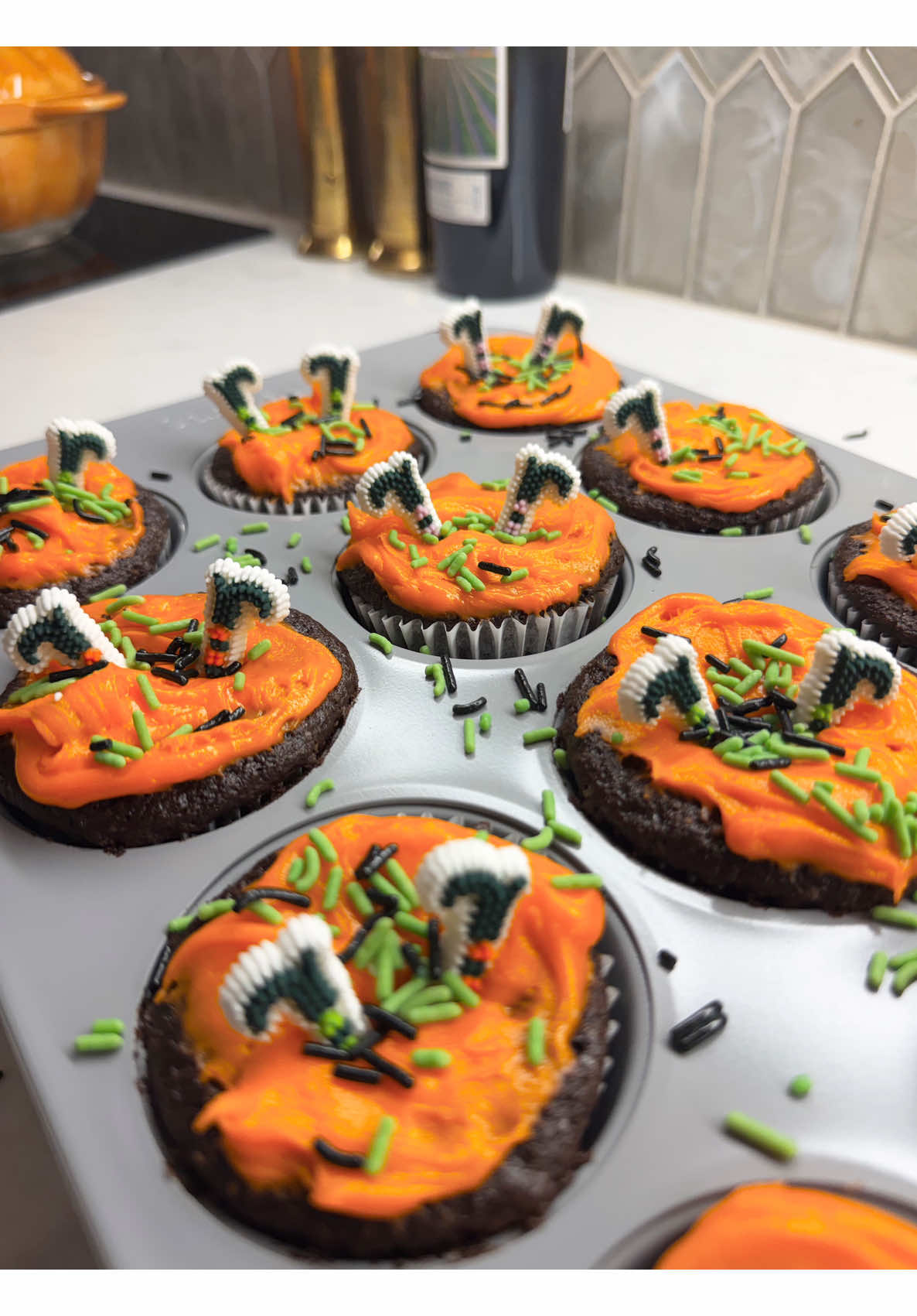 Demonstrating easy Halloween cupcakes with orange frosting, witch ...