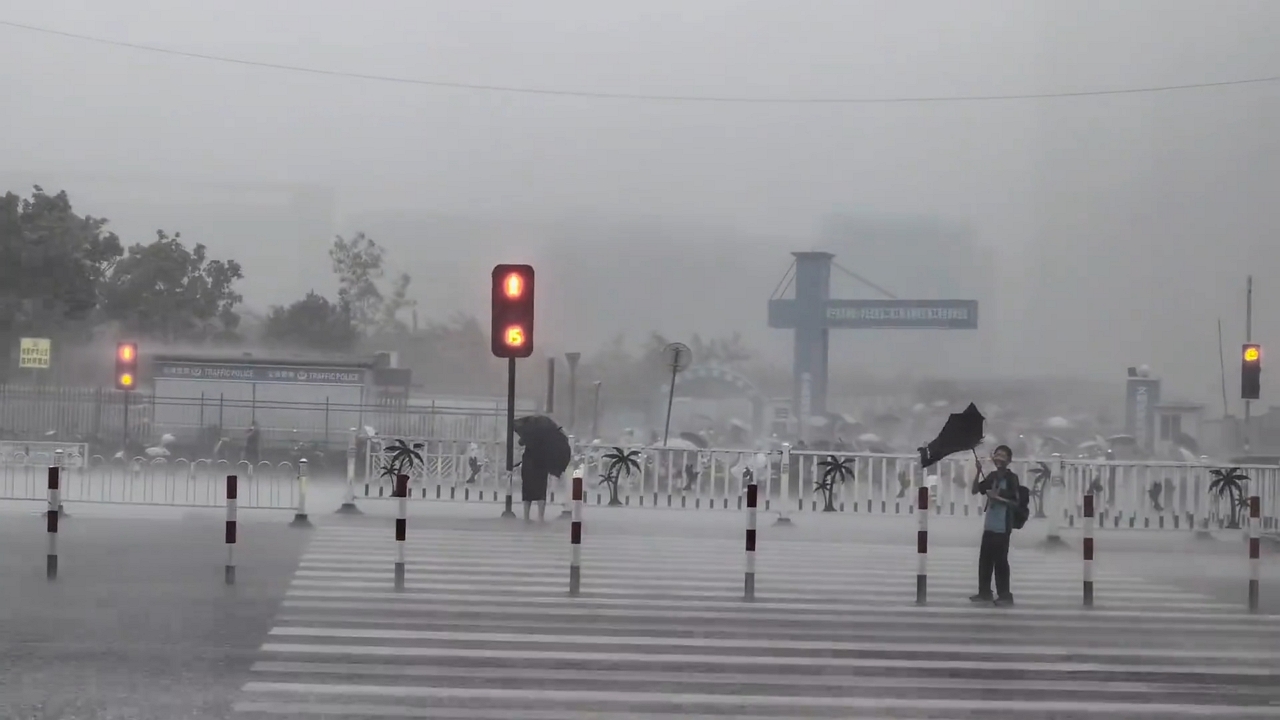 Boy battles fierce storm while crossing street in Guangxi
