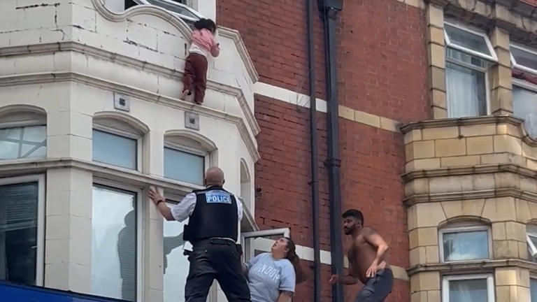 Child dangling from window saved in dramatic rescue