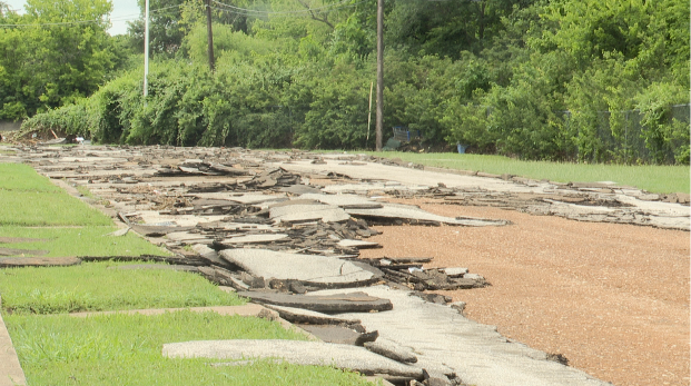Flooding along Waco Drive tears up road in front of apartment complex