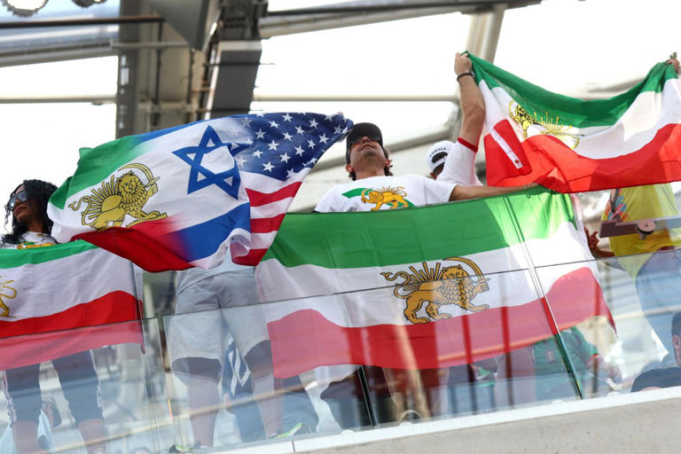 Iranian World Cup soccer fans wave pre-revolutionary flag inside ...