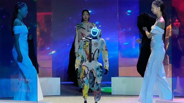 Robot umanoidi sfilano con le modelle a una sfilata di moda a Seul