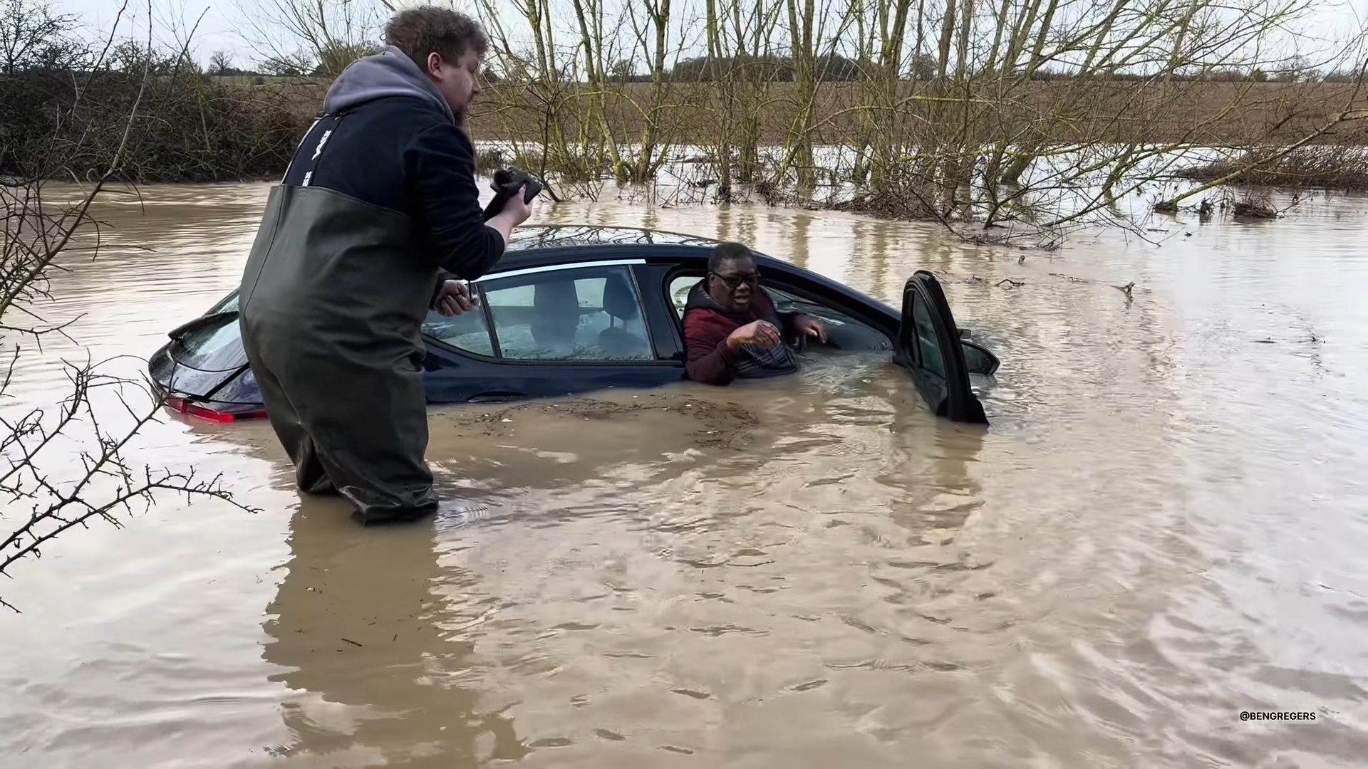 Driver trapped after car sinks in flooded road