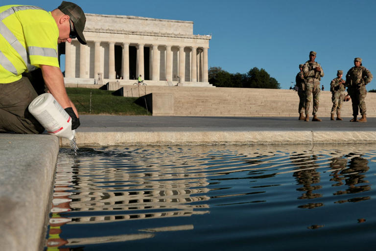 Workers bleach reflecting pool after it turns green