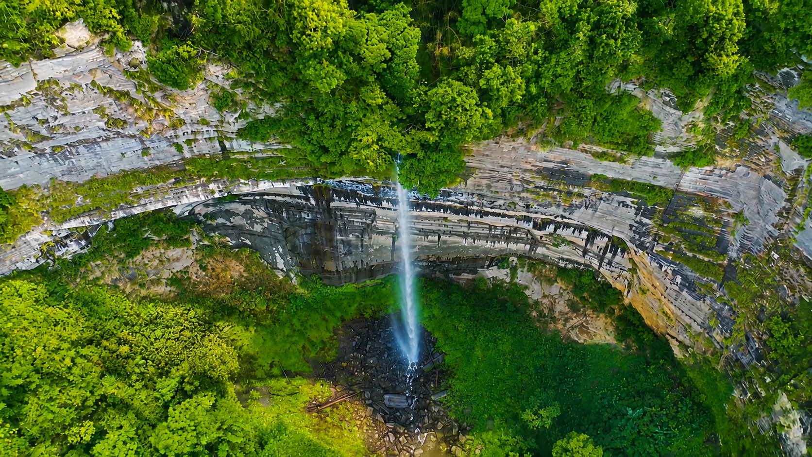 Een verborgen waterval diep in de weelderig groene canyon van Bandarban