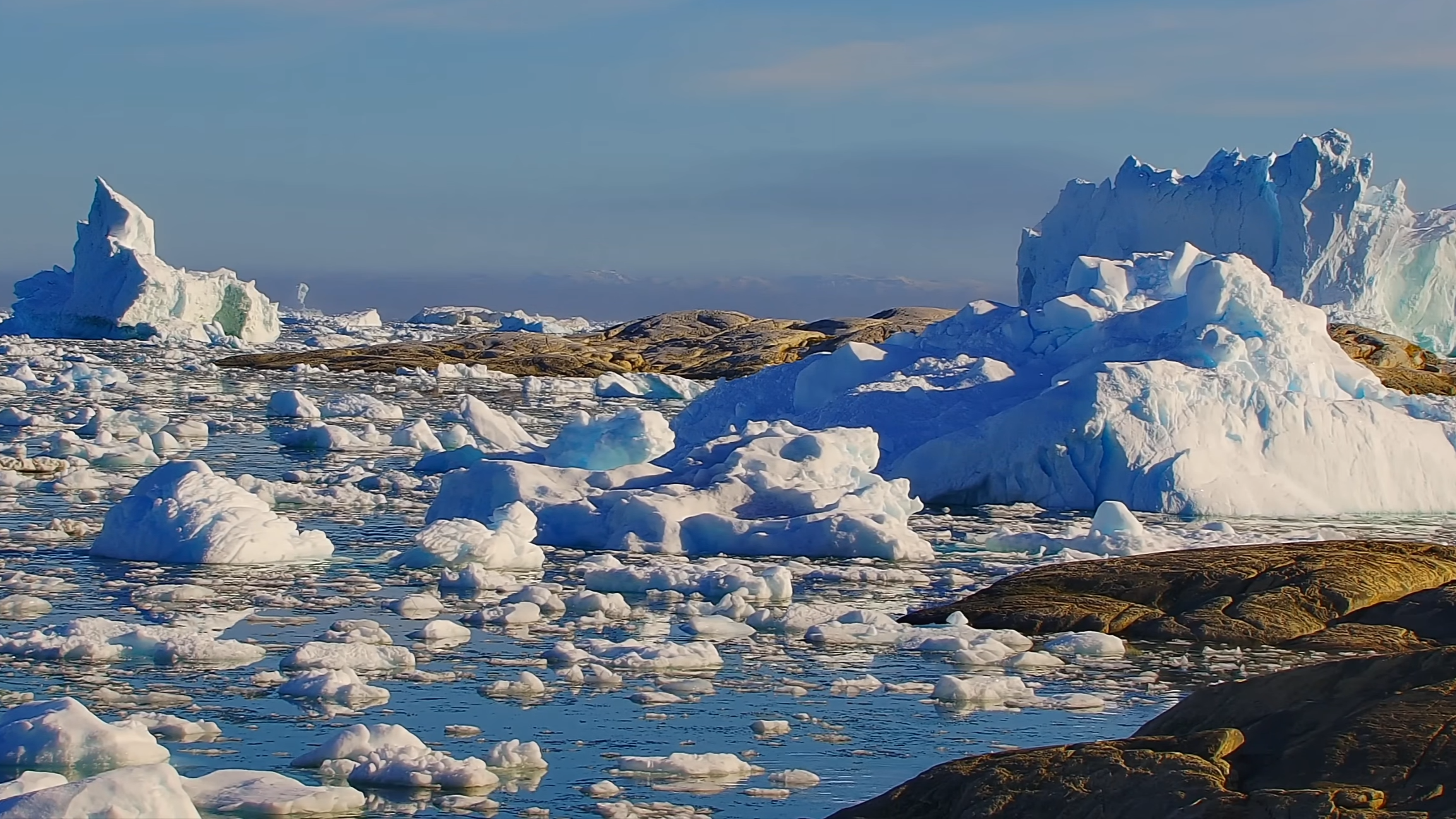 Watch a huge chunk of glacier fall into the sea and trigger a wave