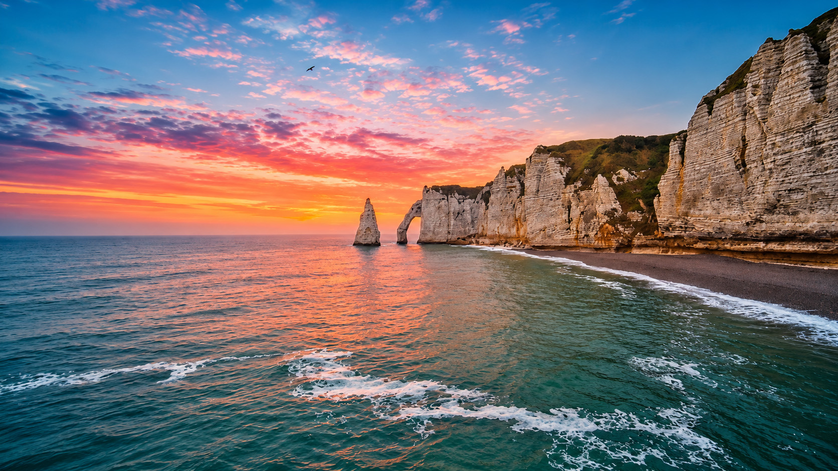 Étretat’s white cliffs and natural arches glowing at sunset