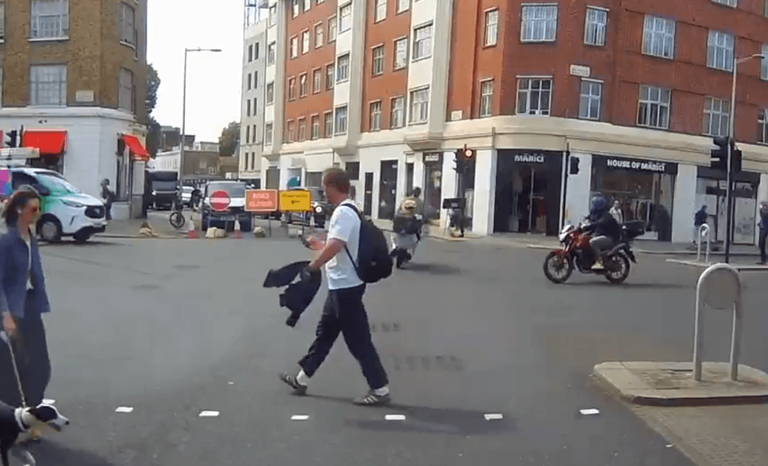 Woman cycles through red lights at busy junction with three children ...