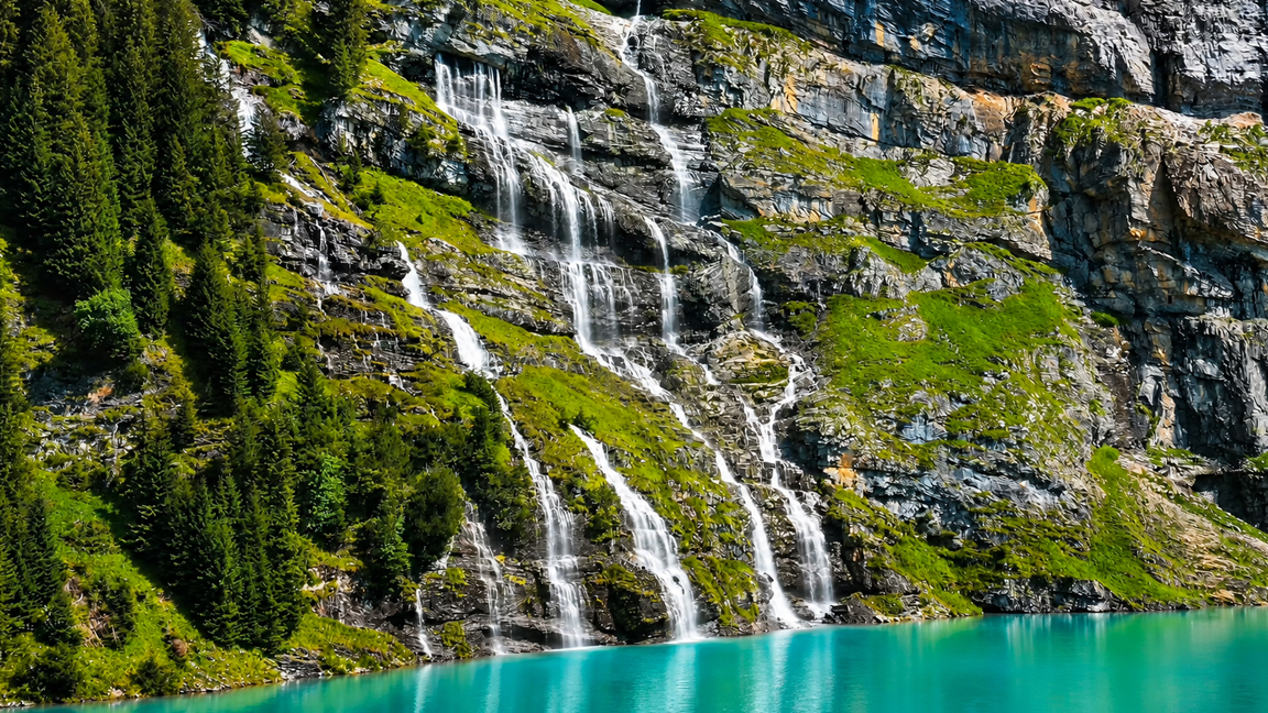 A hidden waterfall above crystal blue water
