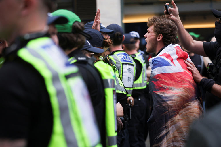 Tommy Robinson speaks to half-empty hall as protesters block debate