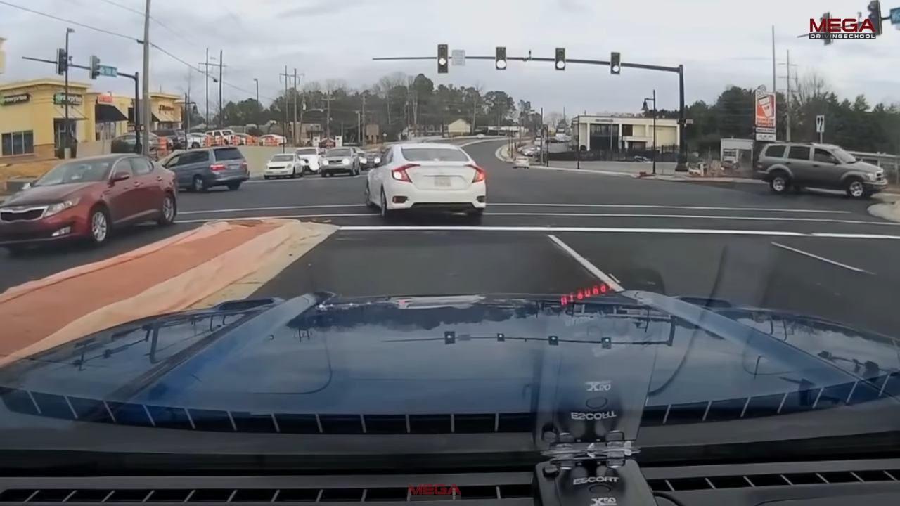 A risky U-turn at the yellow light ends in disaster