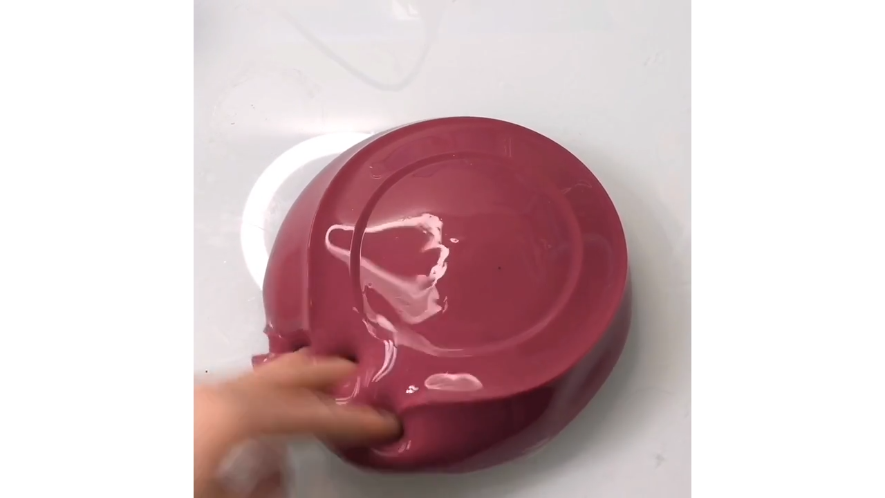 Poking and pressing deep rose jelly slime creating glossy bubble pops