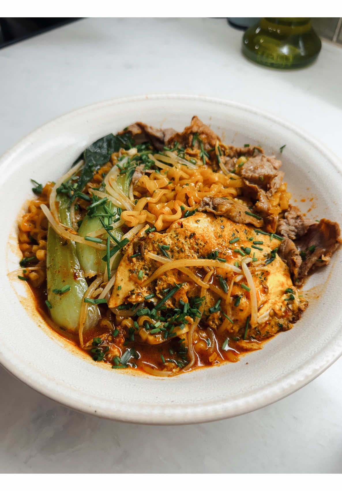 A spicy beef ramen bowl with bok choy, bean sprouts, and a perfectly ...