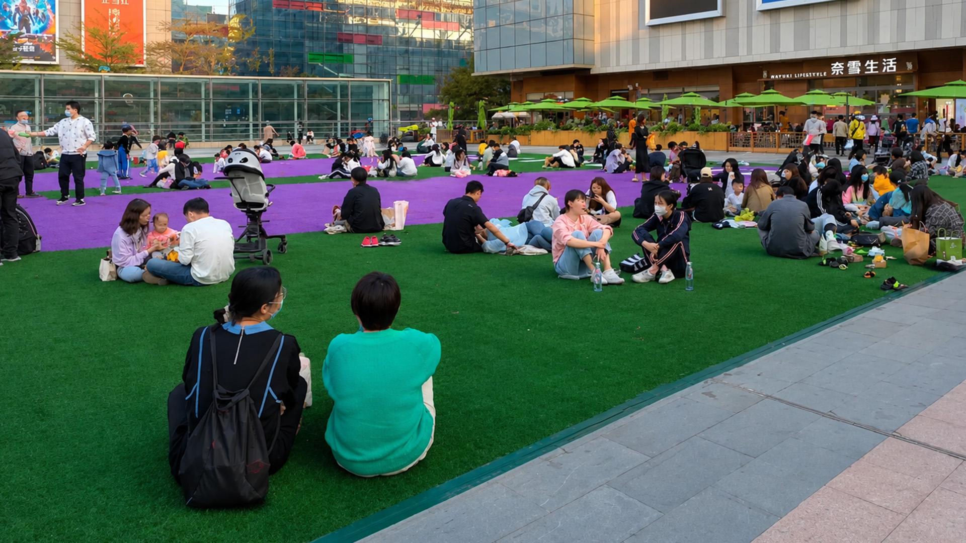 China’s downtown crowd transforms artificial grass into a social escape