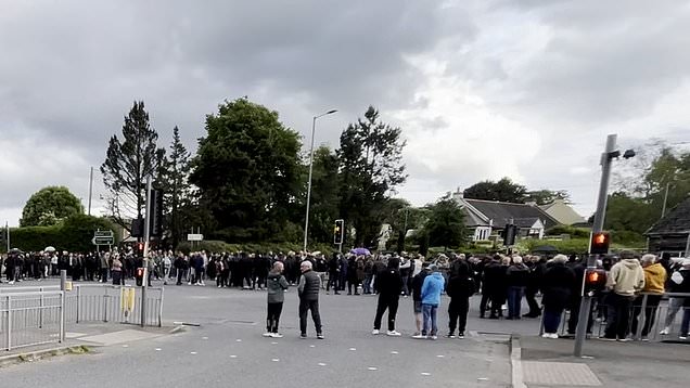 Protesters begin to gather following a knife attack in north Belfast