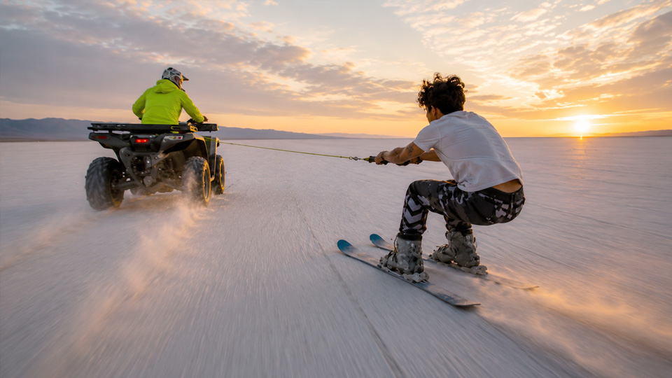 Snowboards glide across salt flats at high speed