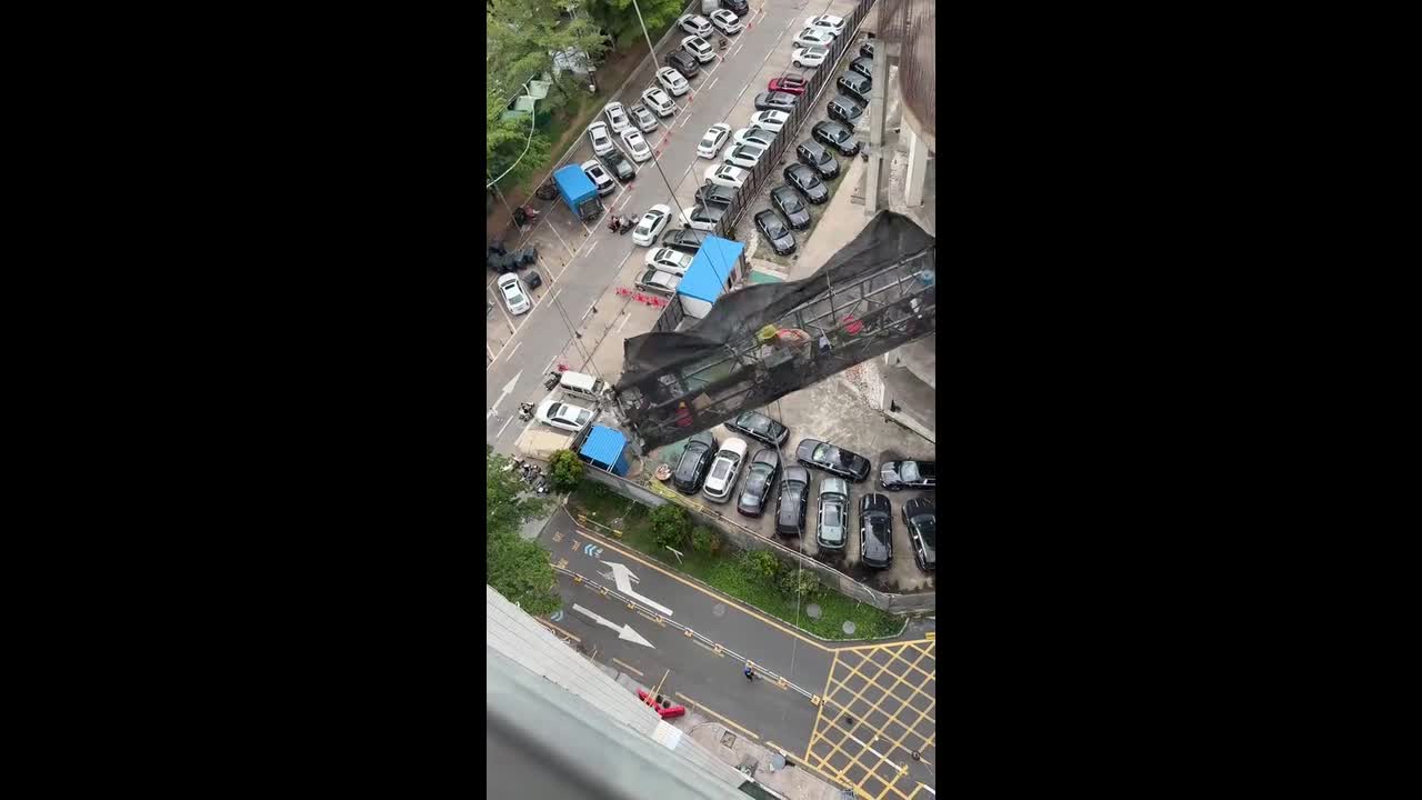 Suspended construction platform swings violently beside skyscraper in ...