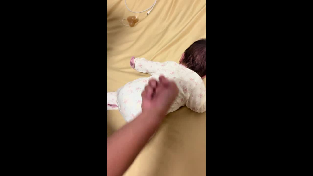 Baby reacts adorably to gentle tickling on bed in Anhui, China