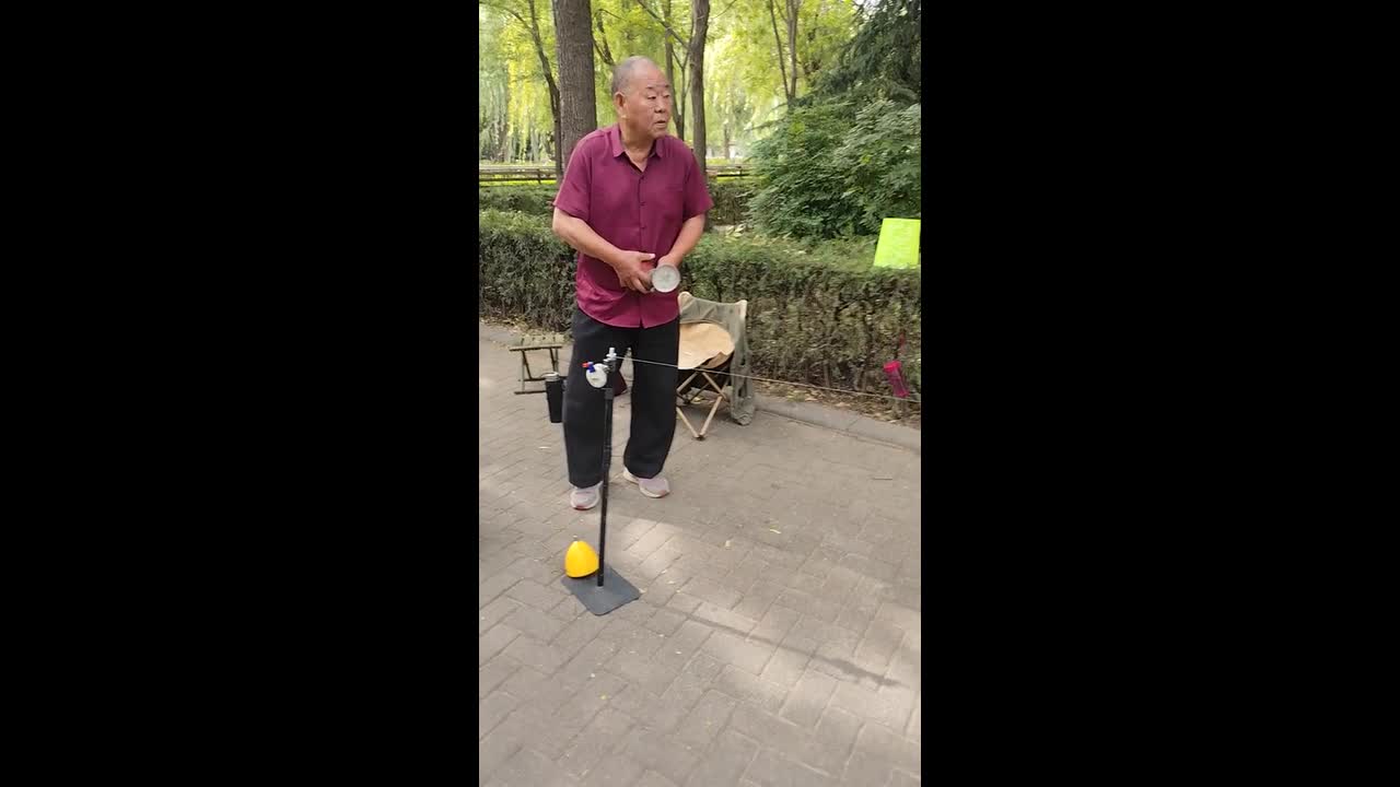 Elderly man performs diabolo trick with spinning top in Henan, China