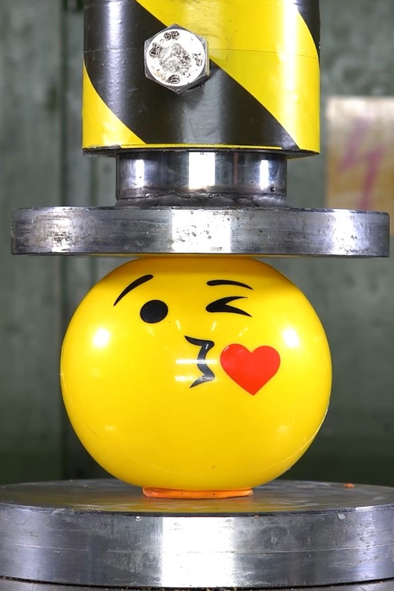 Prasa hydrauliczna miażdży piłkę emoji