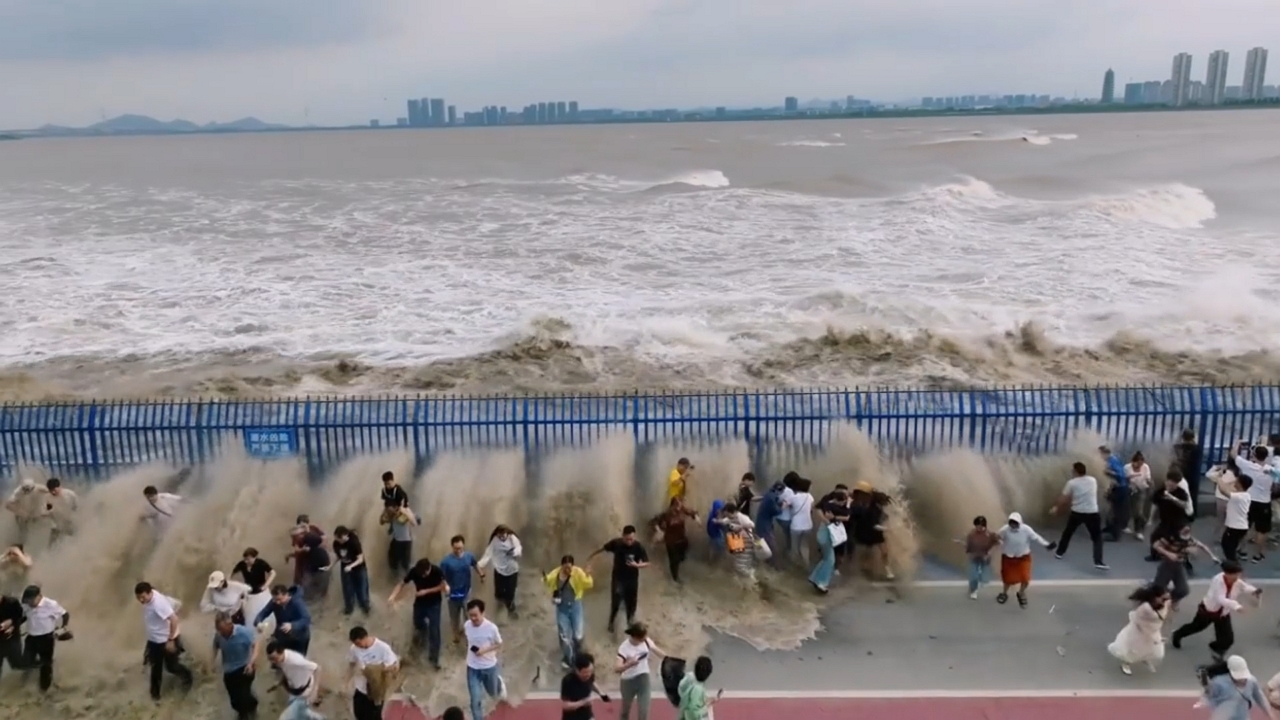 Qiantang River tidal bore crashes over barrier in Zhejiang