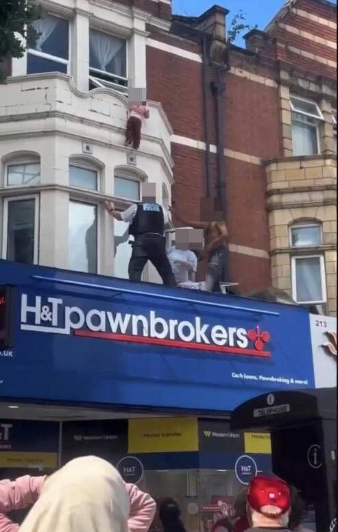 Heroic bystander and police save toddler dangling from window ledge in ...