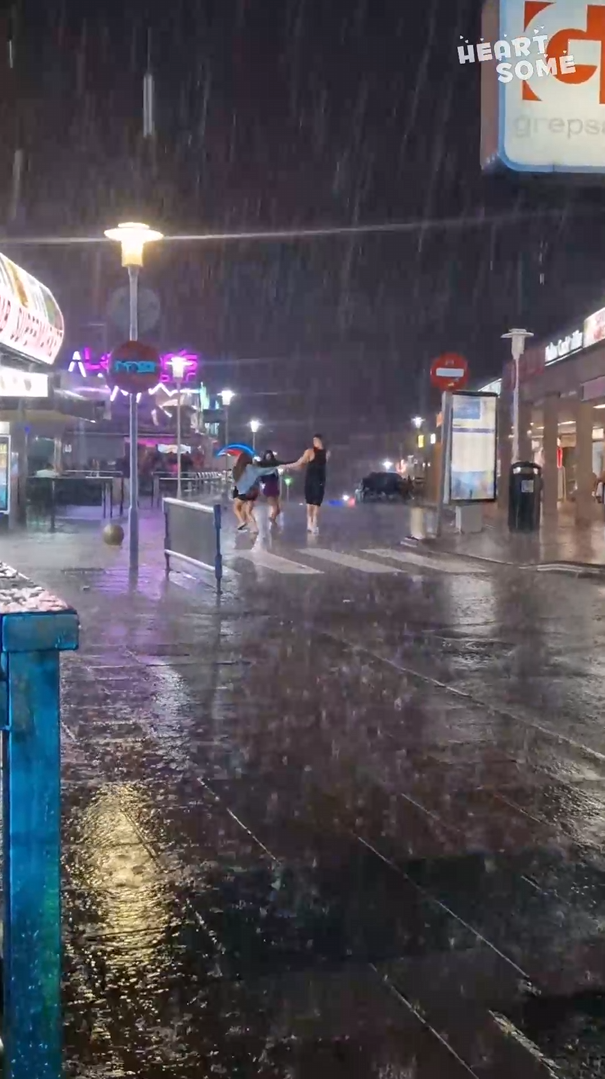 Heavy rain turns into a joyful street moment as people celebrate together