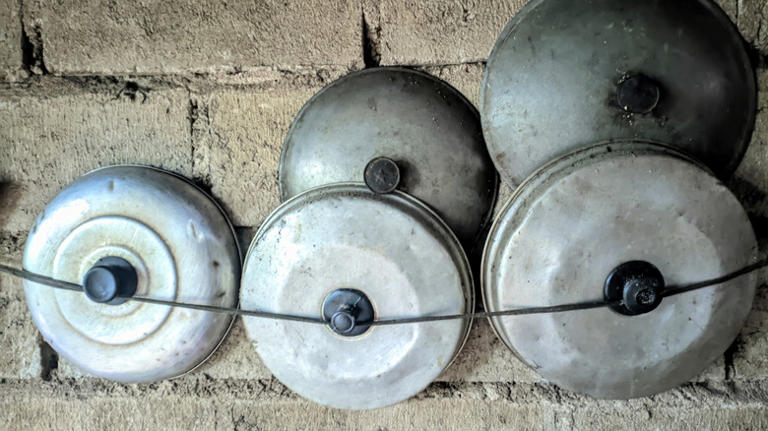 Turn old pot lids into the cutest rustic porch wind chime