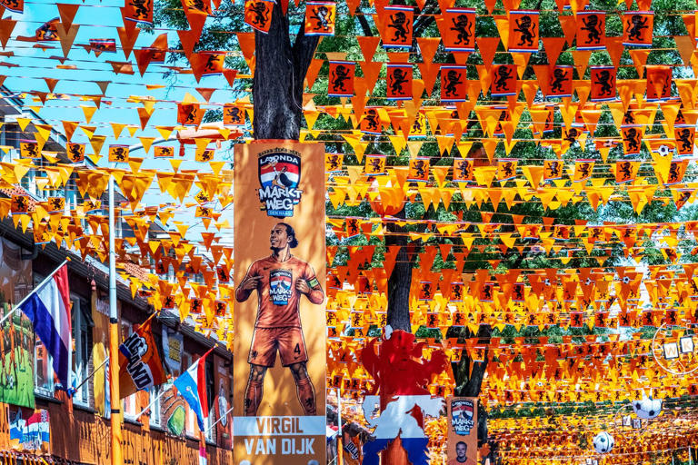 A street in The Hague is drenched in orange as Netherlands soccer fans ...