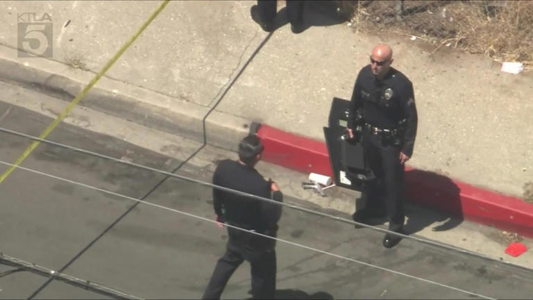 New photos show bullet holes in LAPD officer’s vest, cruiser following ...