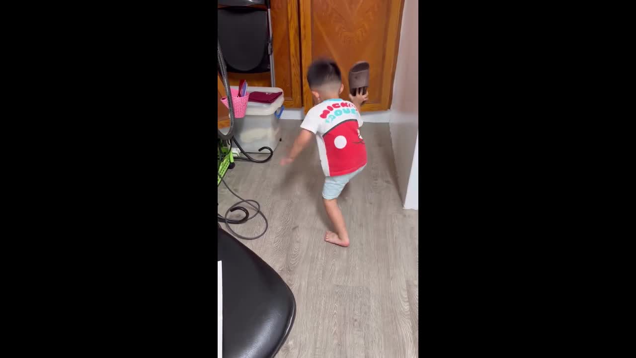 Boy chases cockroach in playful indoor scene in Anhui, China
