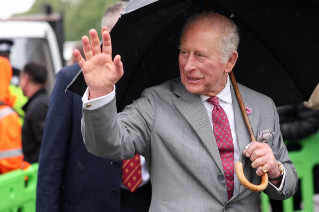 Charles braves downpour to meet football club’s mascot